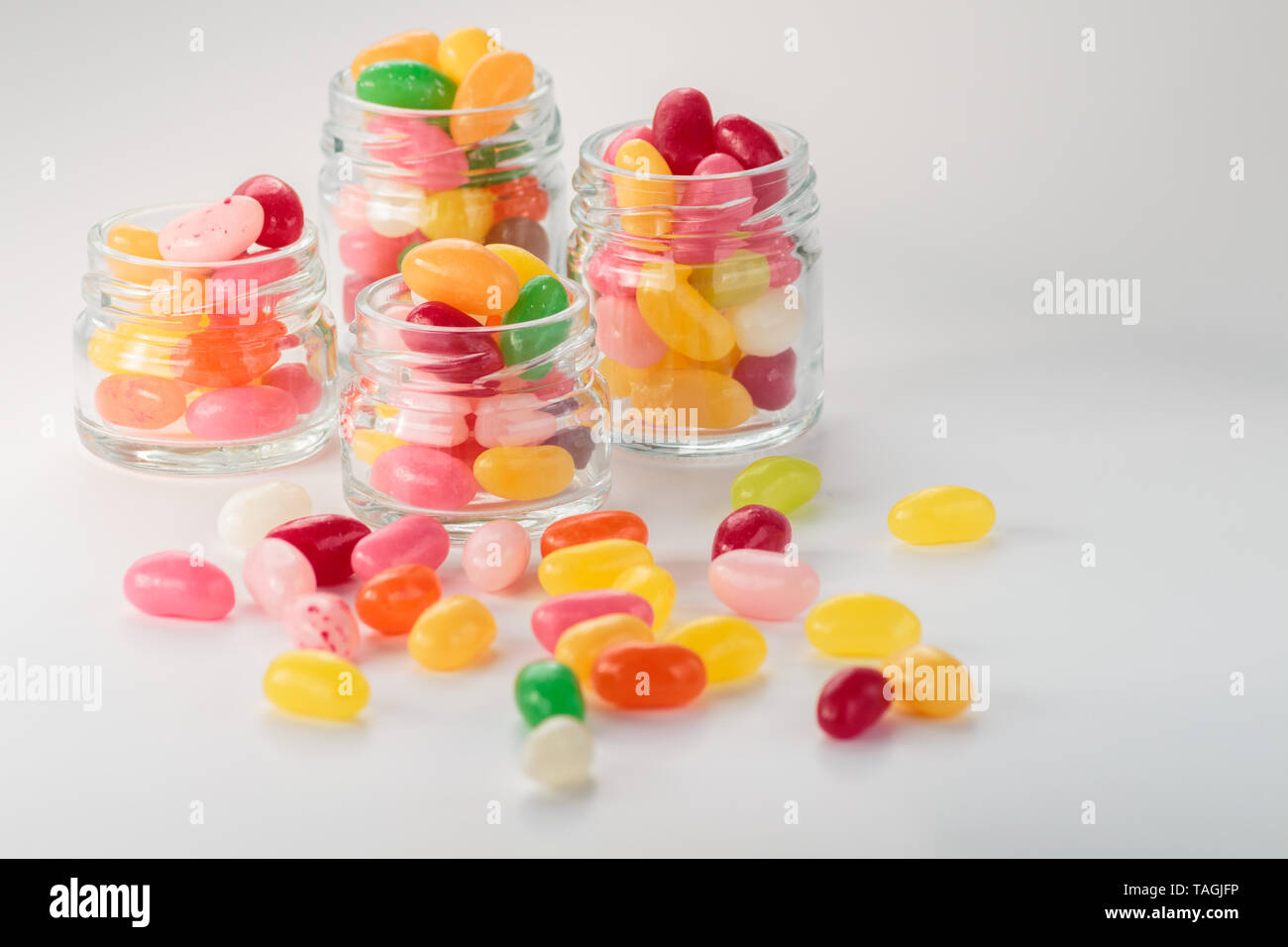 Jelly beans in small glass jars on white background Stock Photo - Alamy