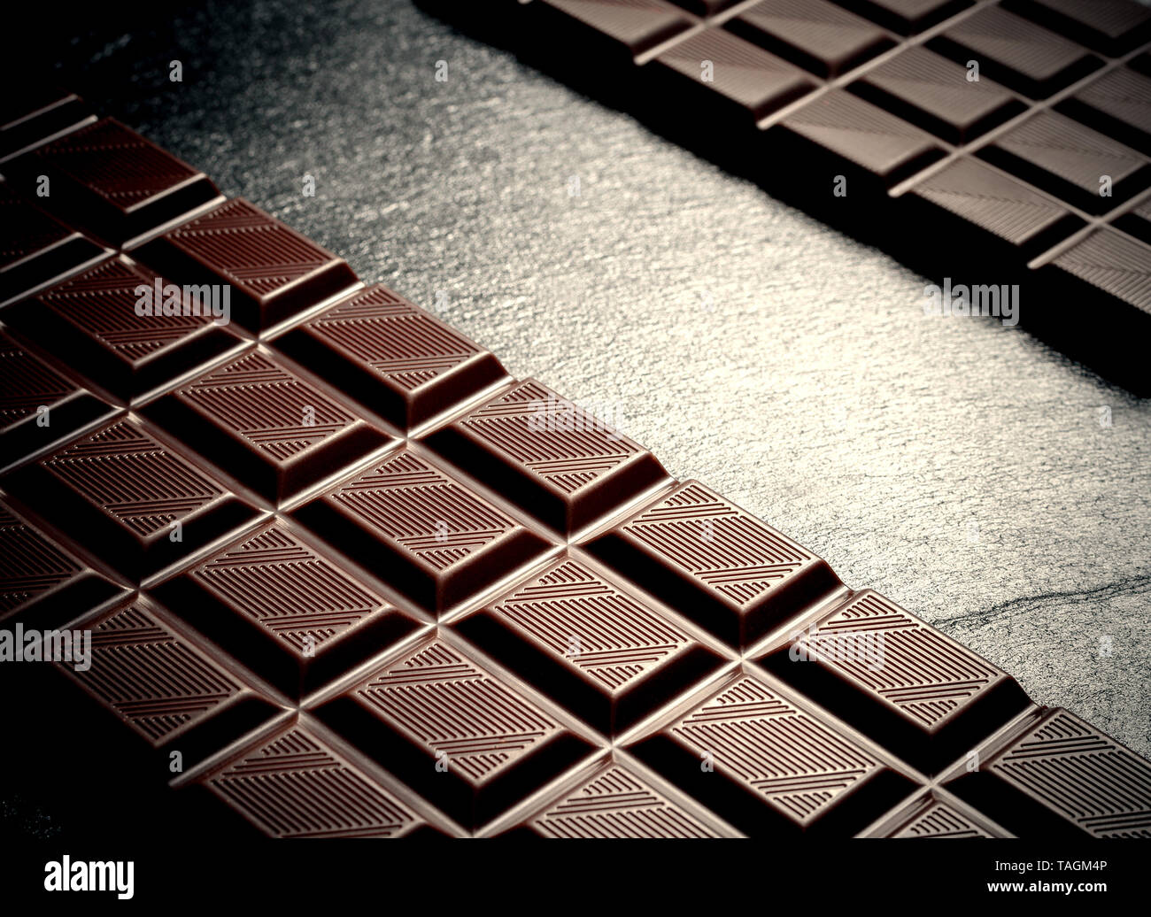 Two black chocolate bars on black slate plate, top view Stock Photo - Alamy