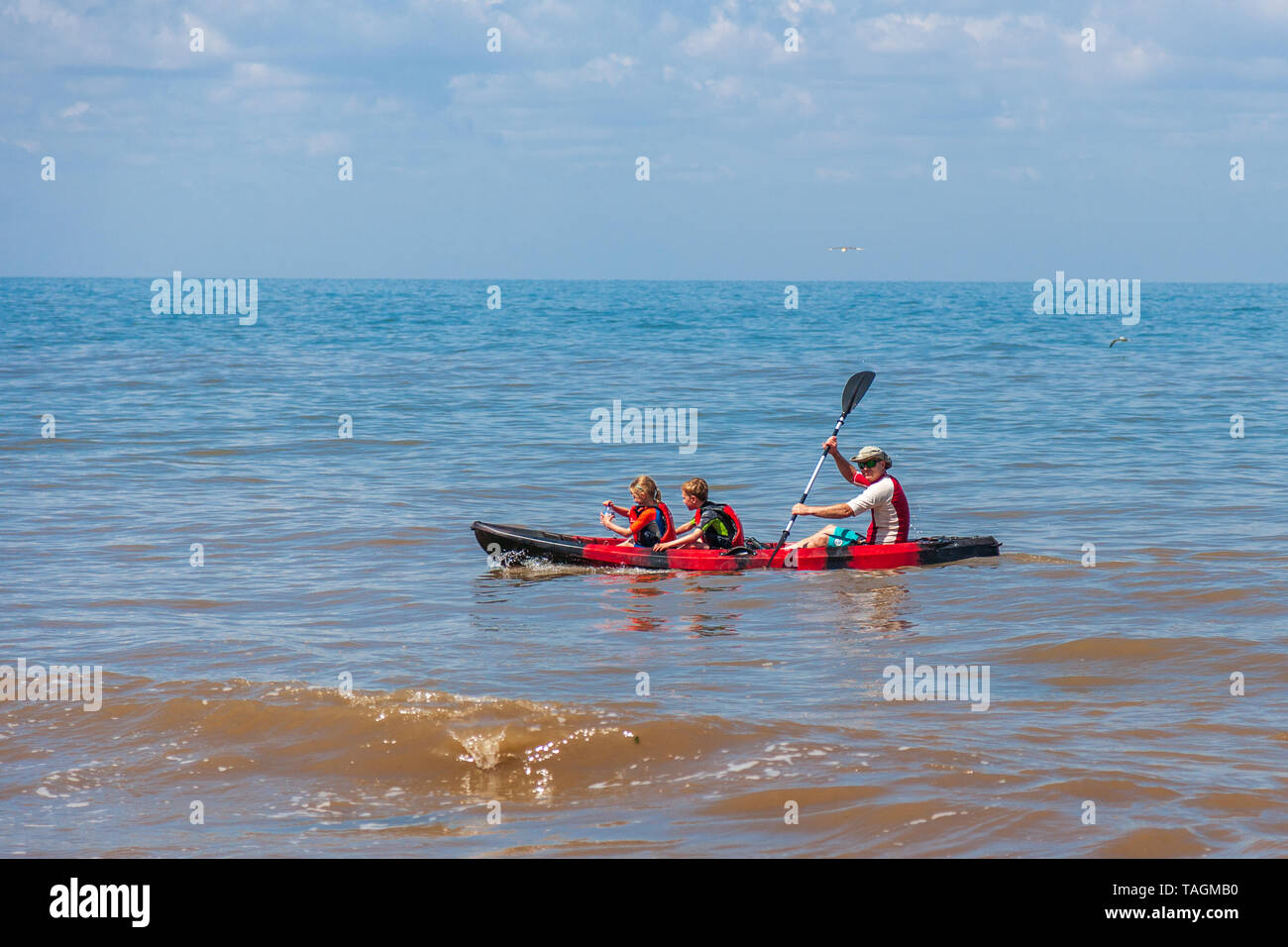 father and two young children kayaking in the sea Stock Photo - Alamy