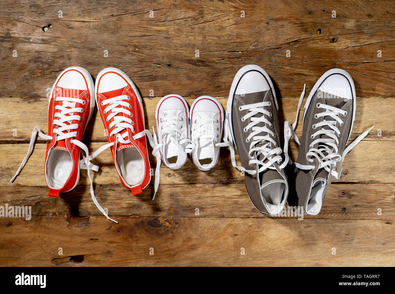 Conceptual image of gumshoes sneakers shoes of father mother and son ...