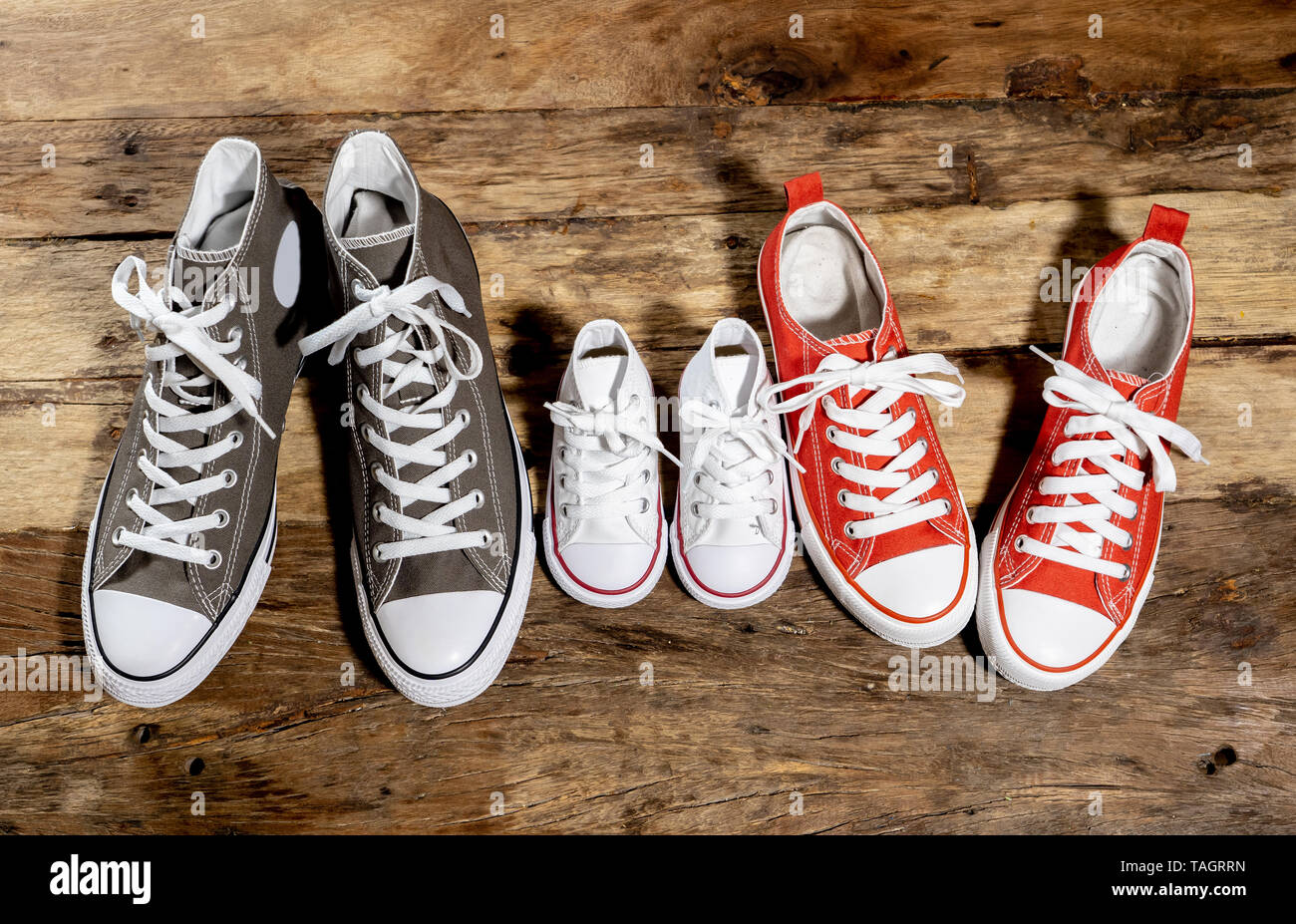 Conceptual image of gumshoes sneakers shoes of father mother and son ...