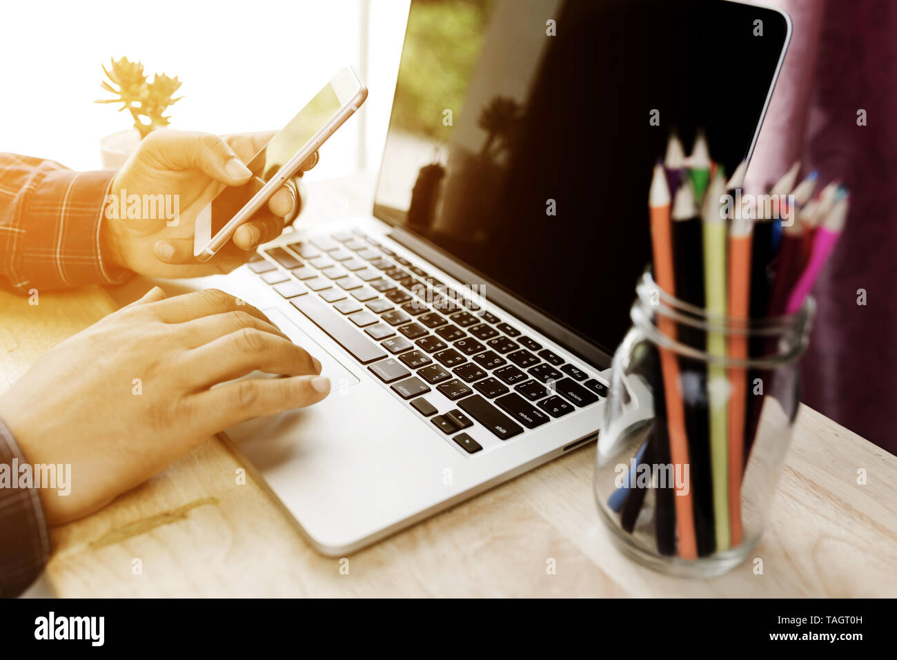 Close up business man hand working on laptop computer on wooden desk as ...