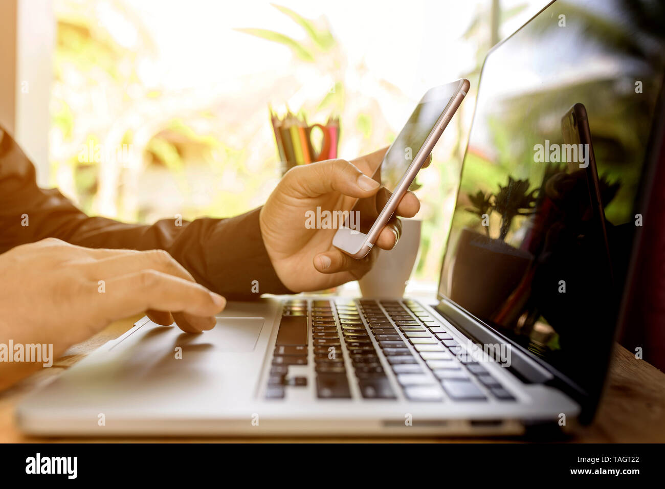 Close up business man hand working on laptop computer on wooden desk as ...