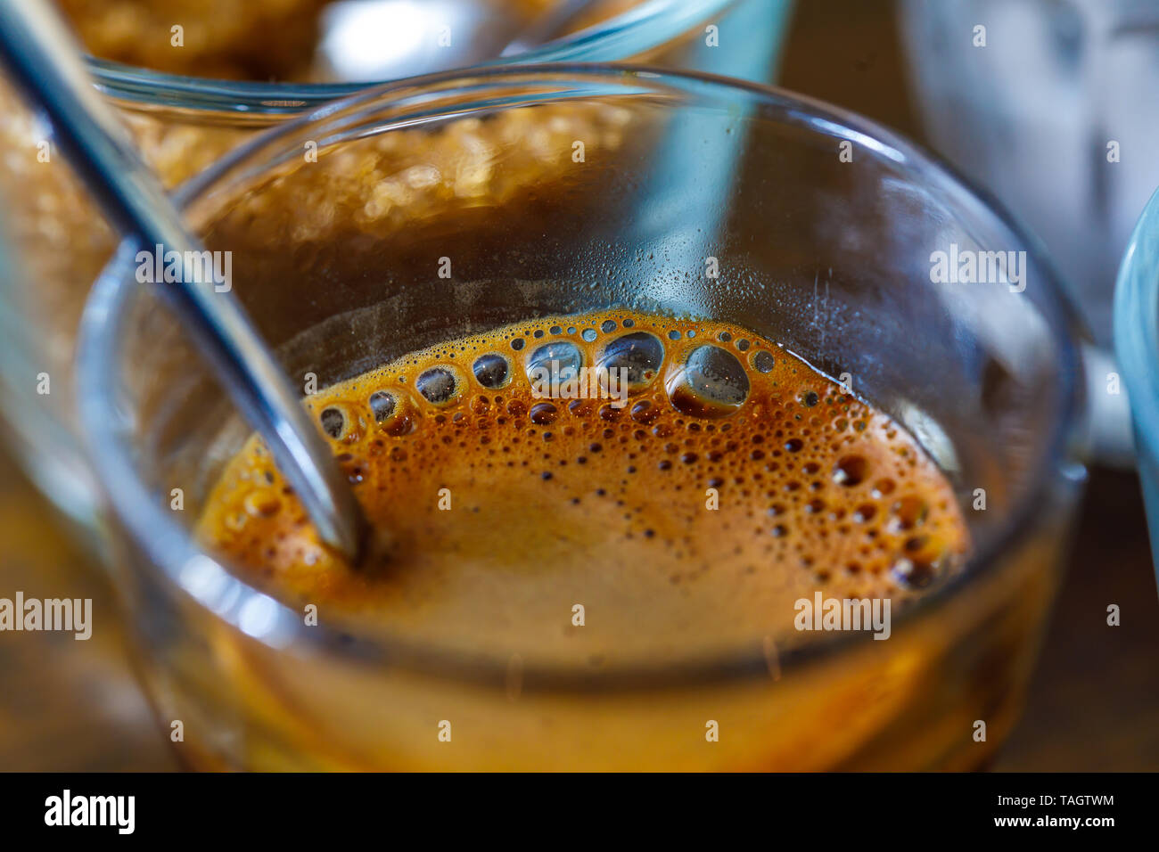 foamy espresso coffee in glass cup with metal spoon and sugar Stock ...