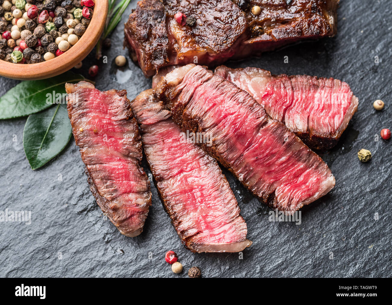 Medium rare Ribeye steak with herbs on graphite board Stock Photo - Alamy