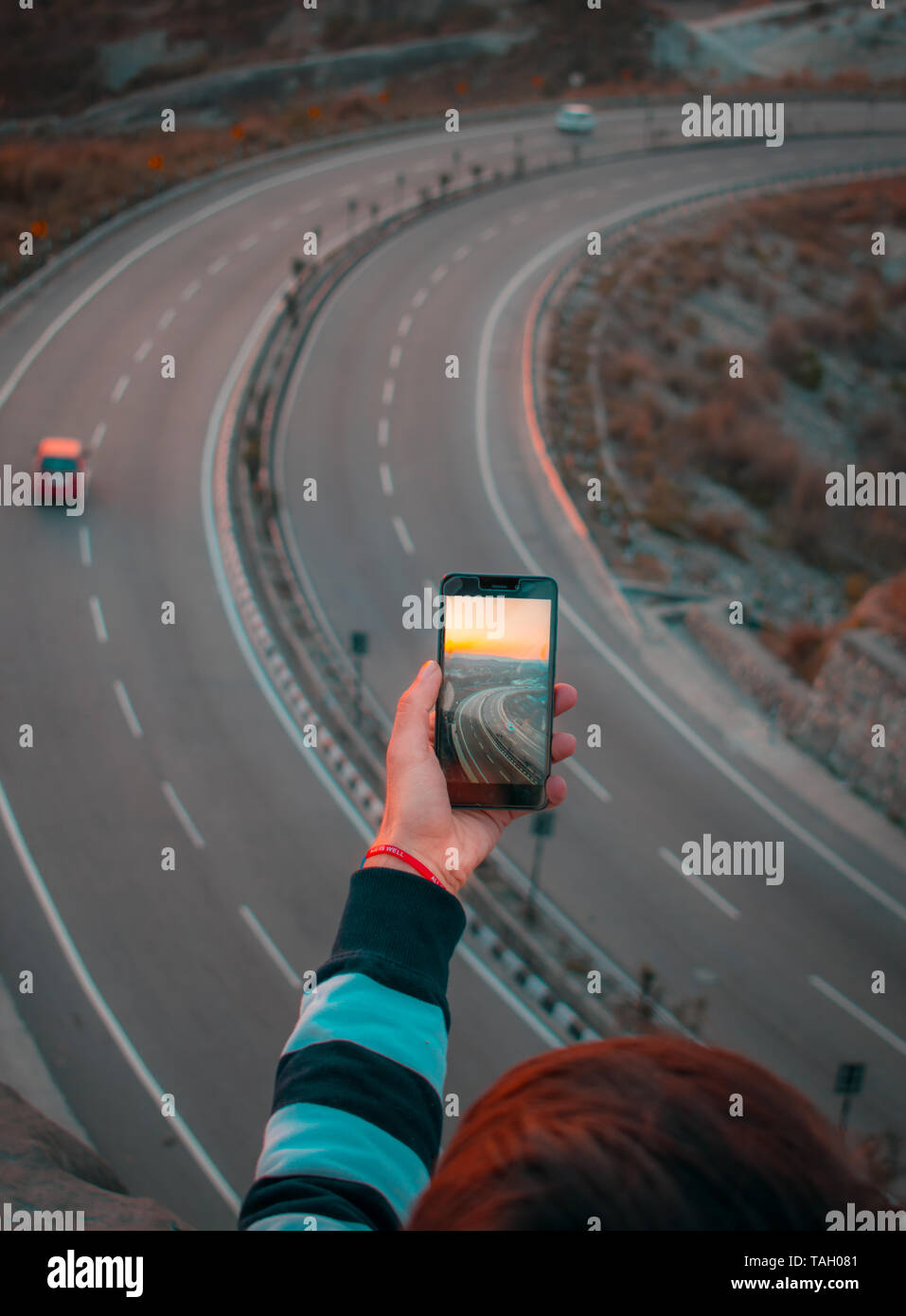 Mirror photo of highway in a phone screen. Boy looking at his phone ...