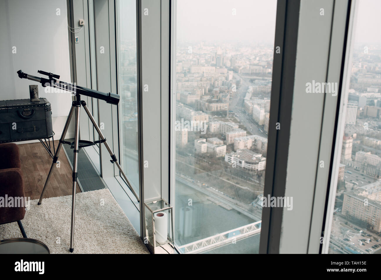 Telescope at window of skyscraper Stock Photo - Alamy