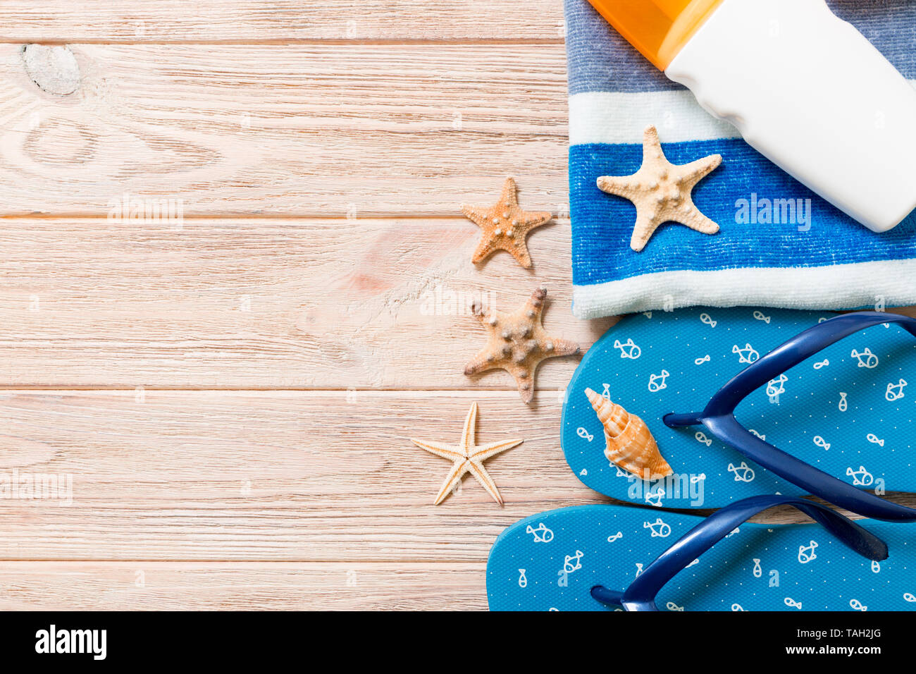 Top view of Beach flat lay accessories. sunscreen bottle with seashells ...