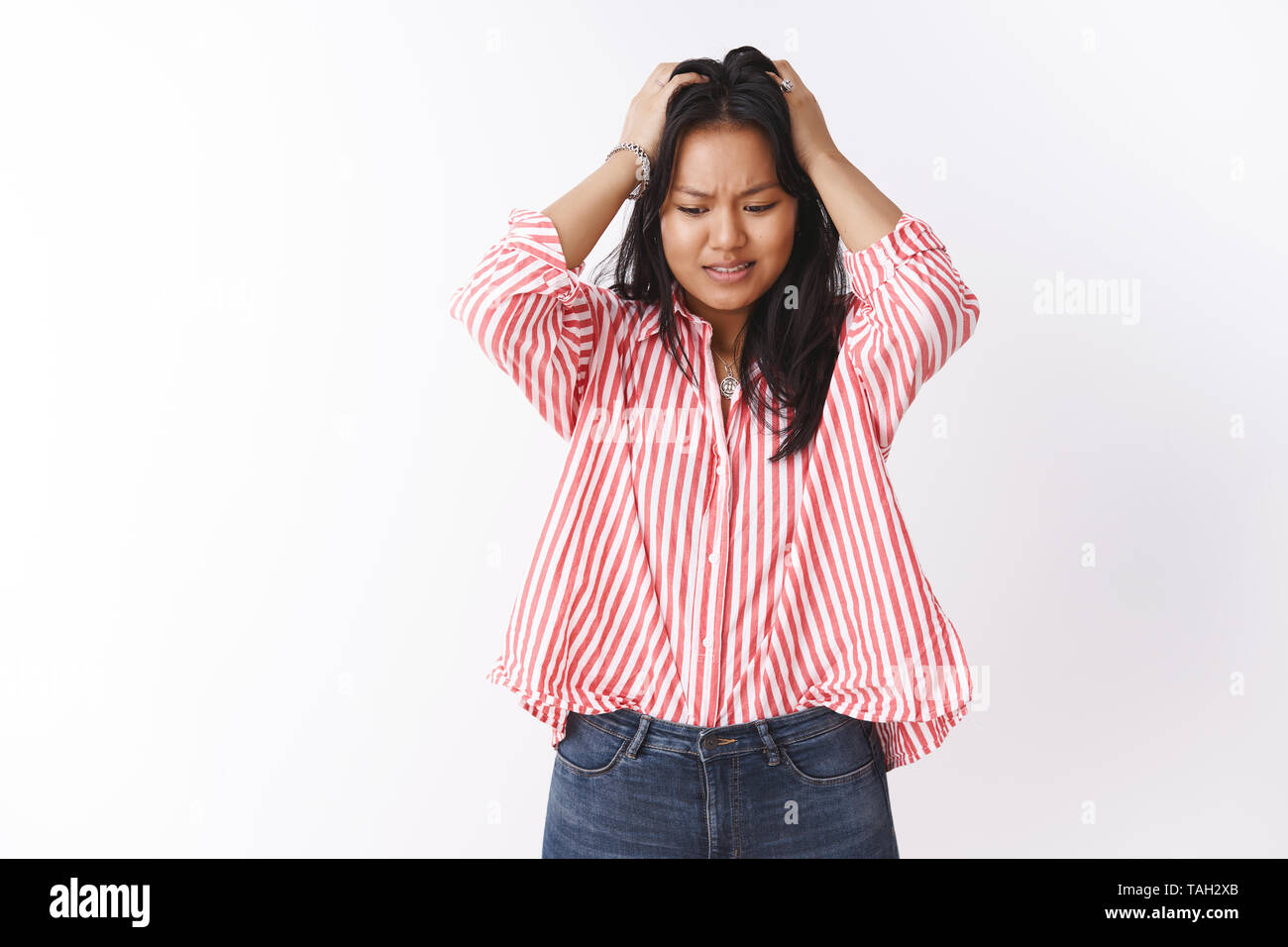 Anxious and troubled worried cute female staff in striped blouse ...