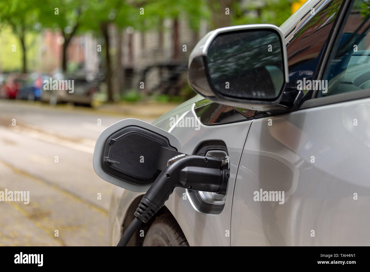 Electric car plugged into an EV charging station Stock Photo - Alamy