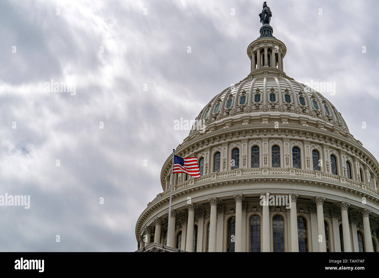 Washington DC Capitol with waving flag on cloudy day Stock Photo - Alamy