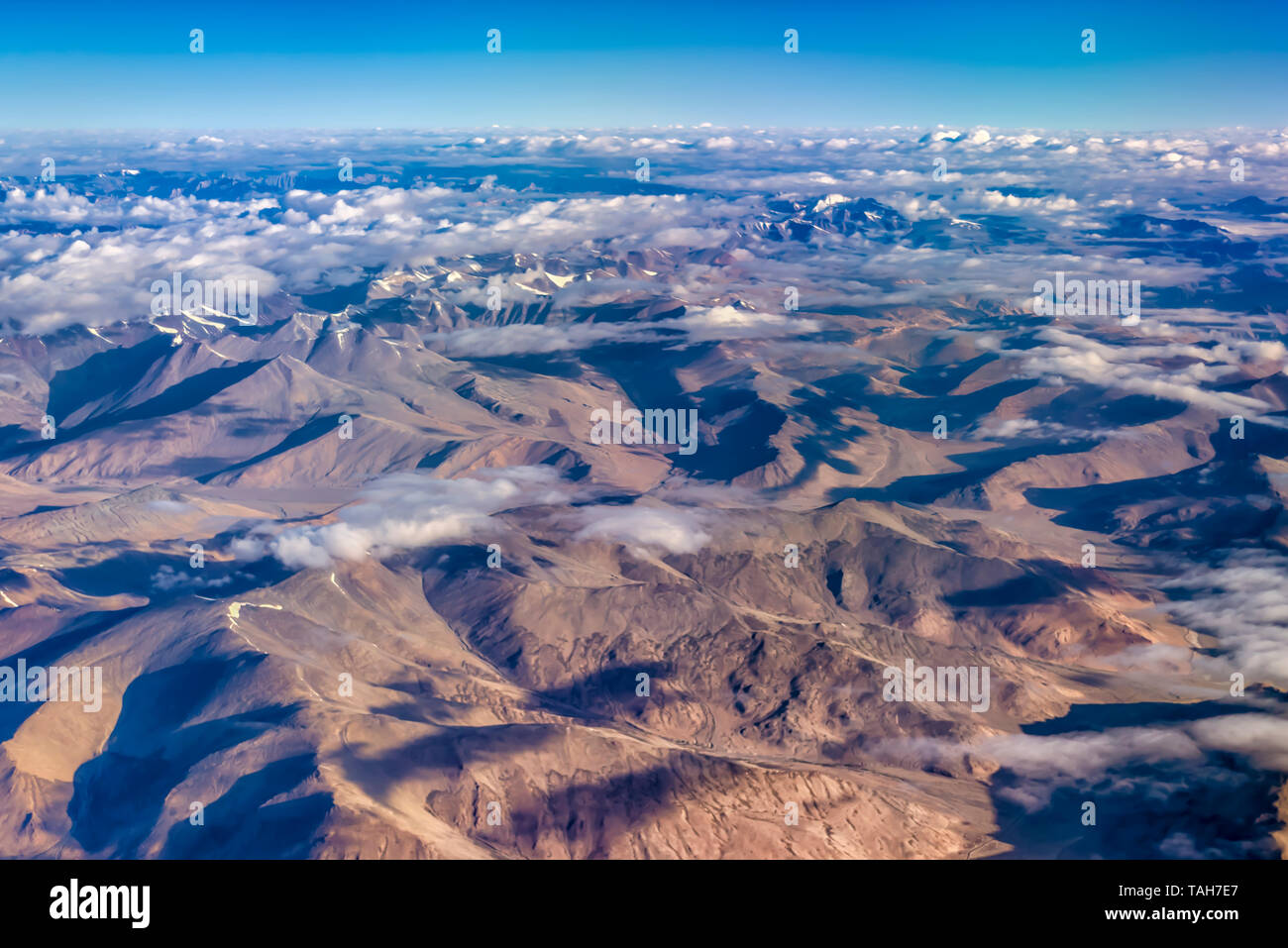 An aerial view of spotty monsoon clouds dotting the barren peaks of the ...