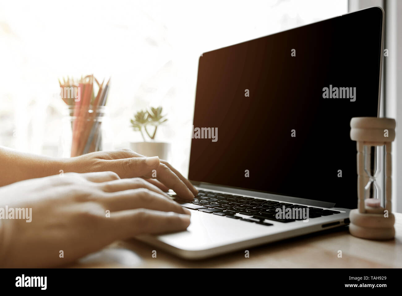 Close up business man hand working on laptop computer on wooden desk as ...