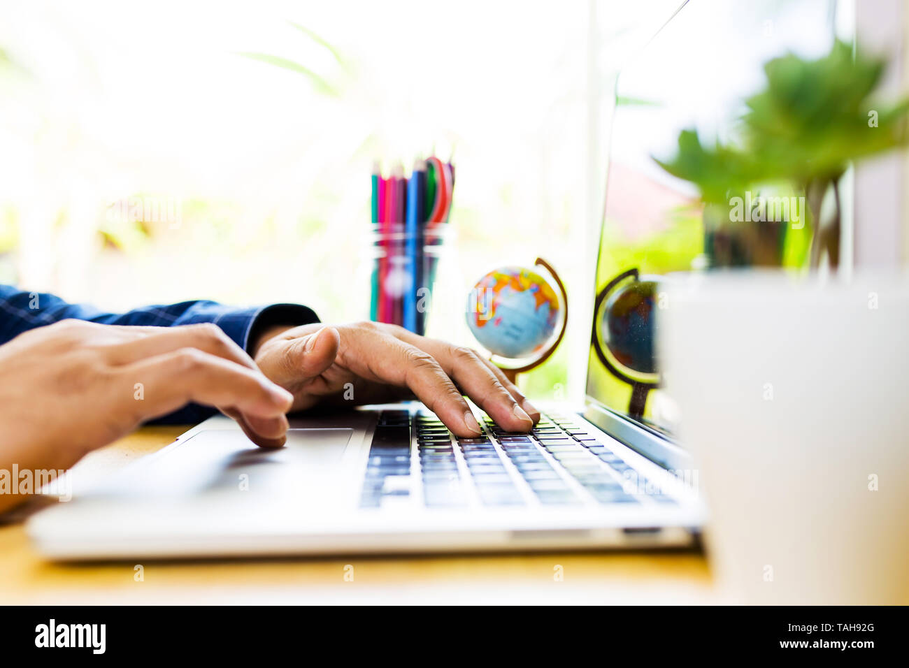 Close up business man hand working on laptop computer on wooden desk as ...