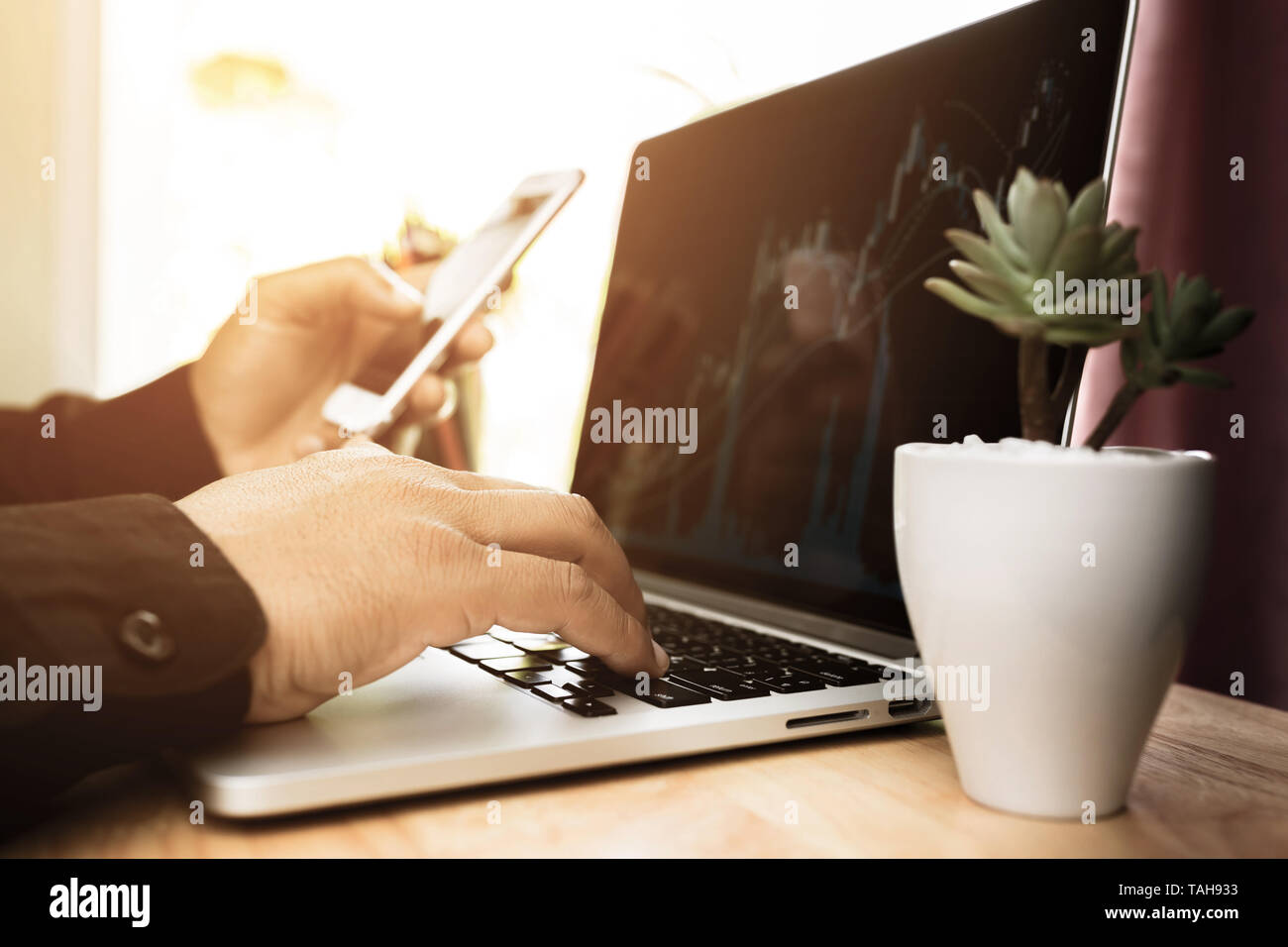 Close up business man hand working on laptop computer on wooden desk as ...