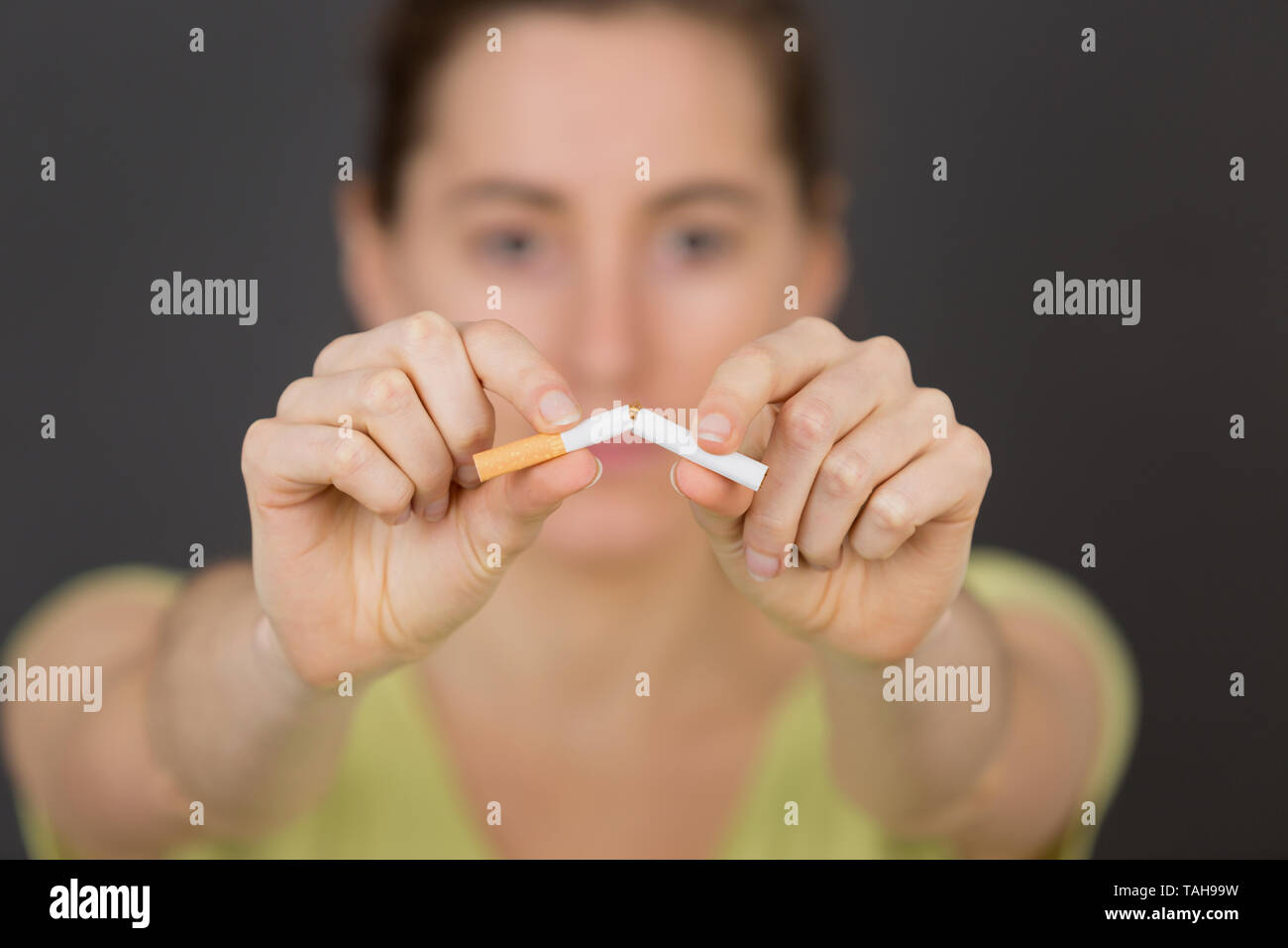 portrait of woman breaking cigarette in half Stock Photo - Alamy