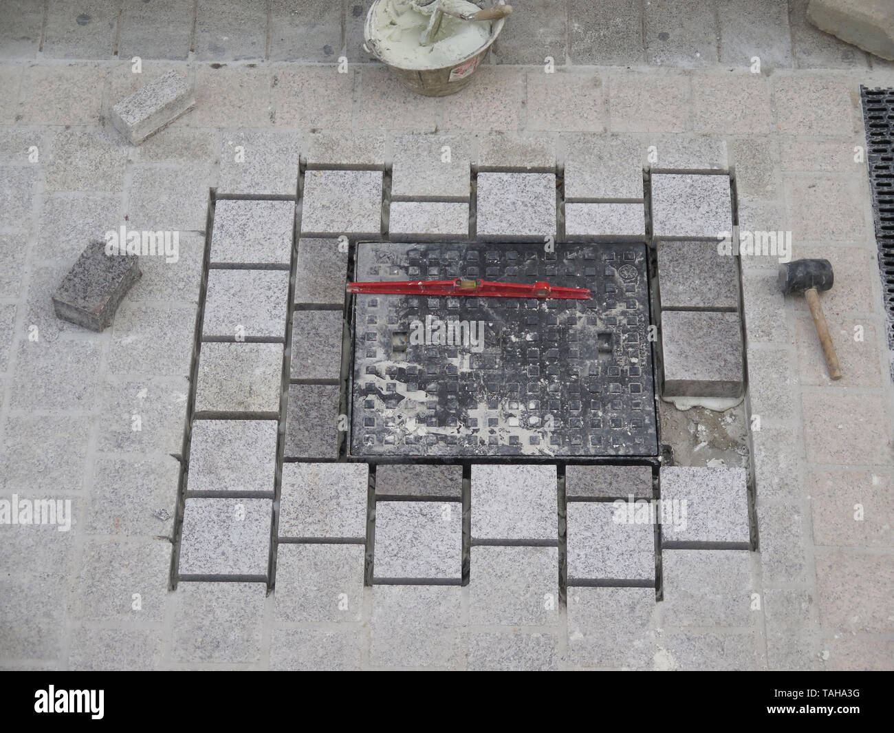 Spirit level and hammer by manhole cover in roadwork site in Andalusian ...