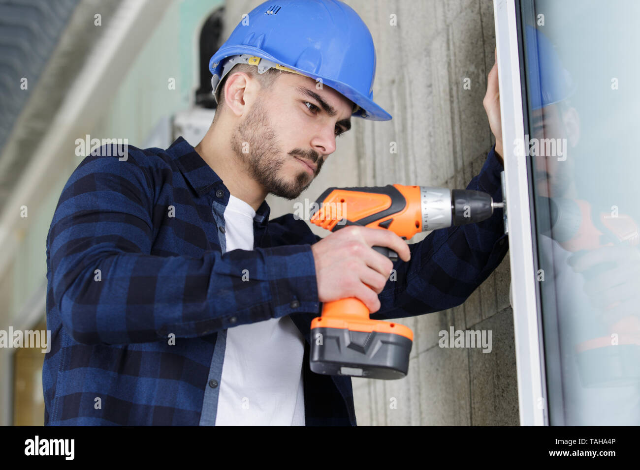 handyman using a cordless screwdriver to install a window Stock Photo ...