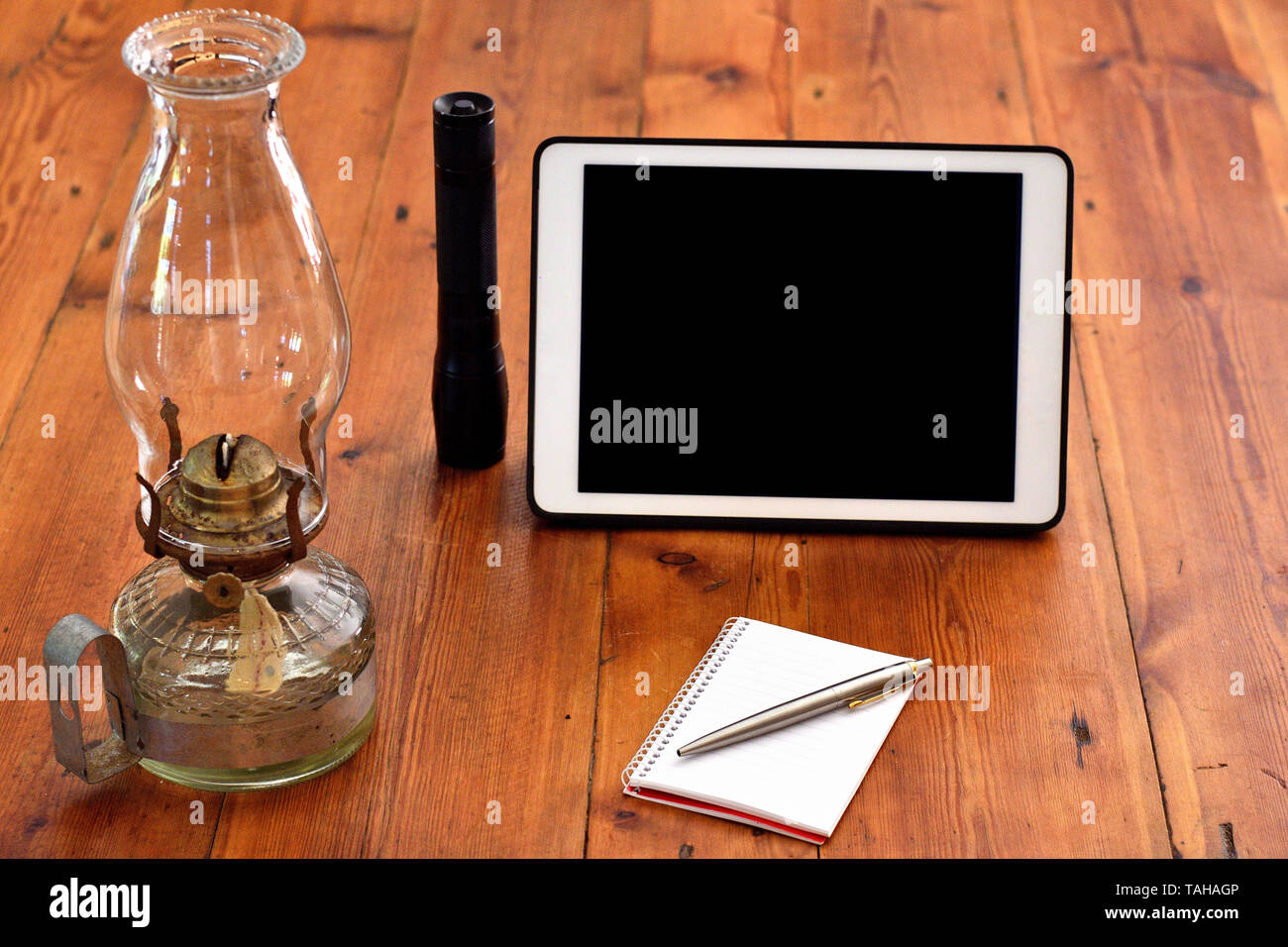 Writing equipments placed next to gadget plus a classic vintage lantern ...
