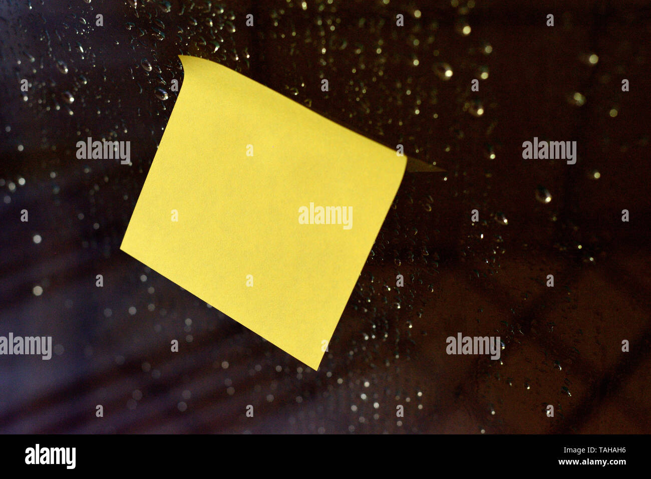 Piece of square sheet use to give notation stick to dewy wet glass ...