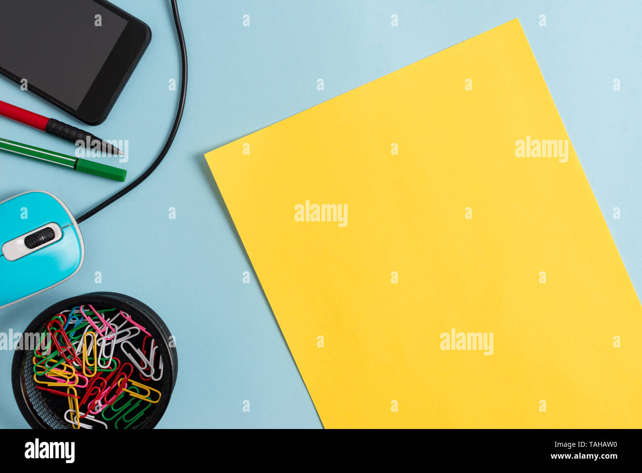 Cardboard and writing equipment with modern gadget above pastel ...