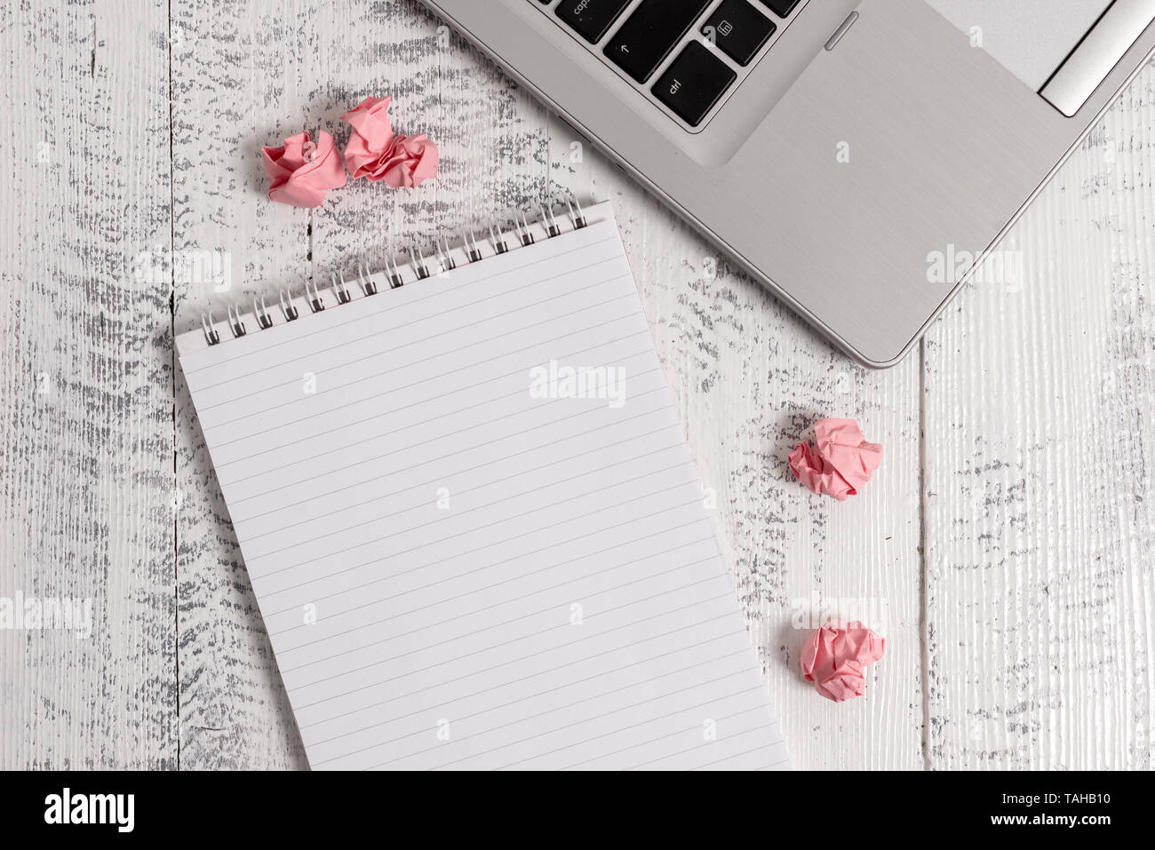 Laptop ruled spiral notepad crushed paper balls lying wooden vintage ...