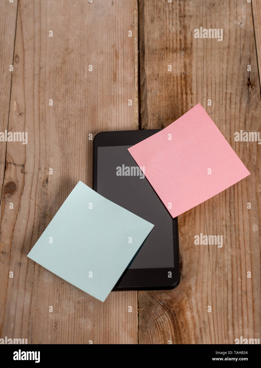 Smartphone two colored sticky notes lying vintage old wooden background ...