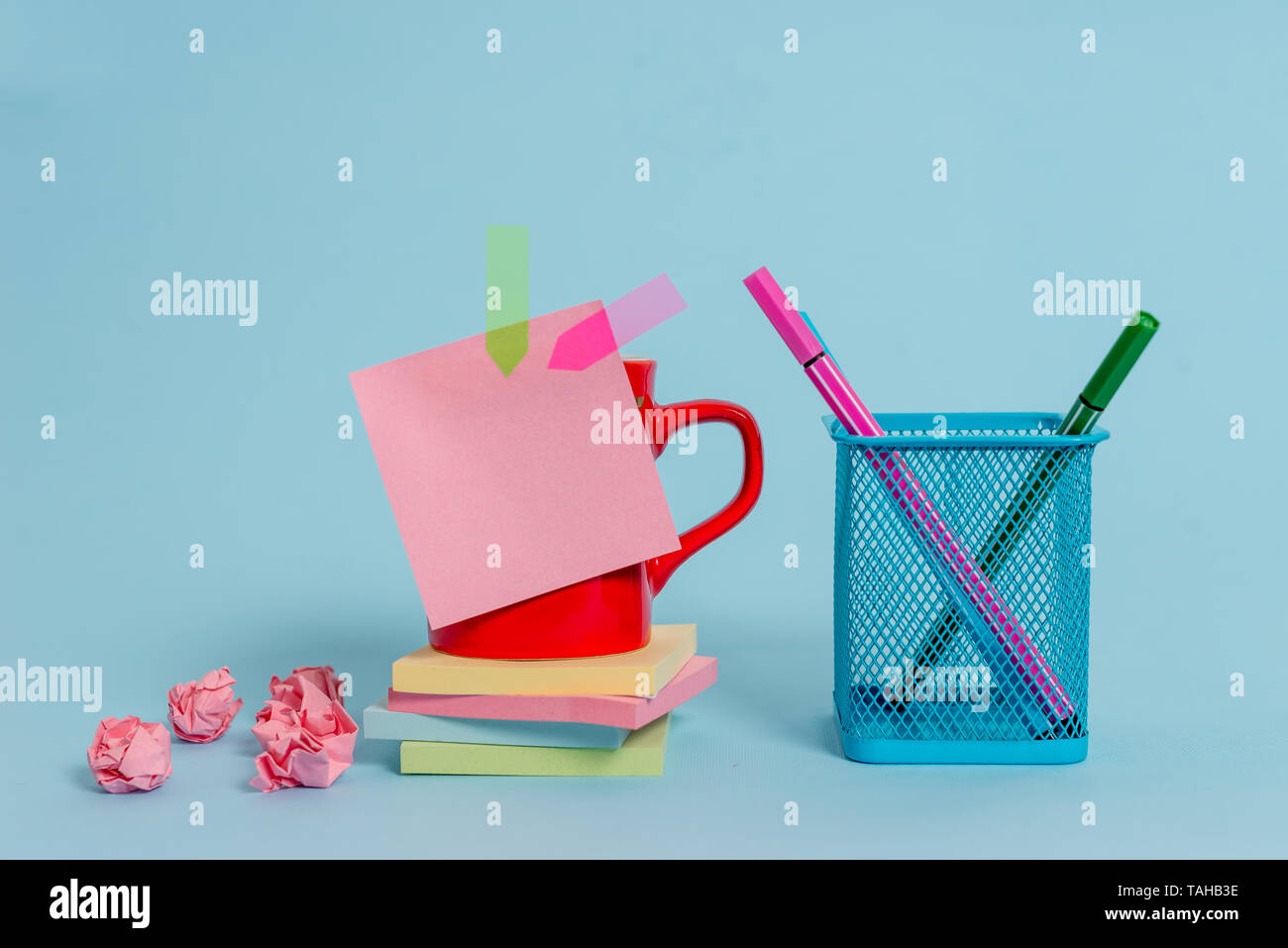 Cup pens holder note banners stacked pads paper balls pastel background ...