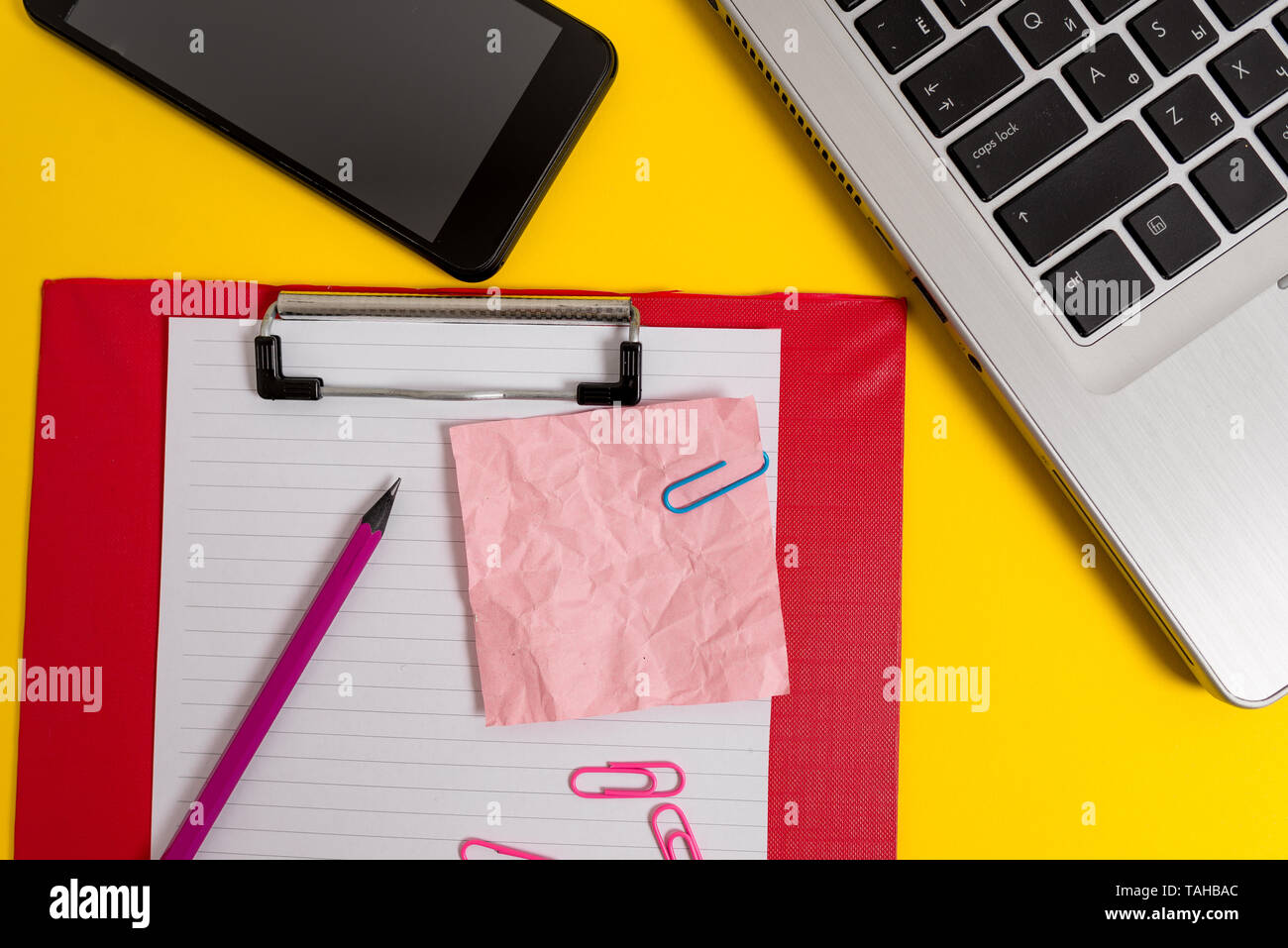Laptop clipboard sheet clips pencil note smartphone colored background ...