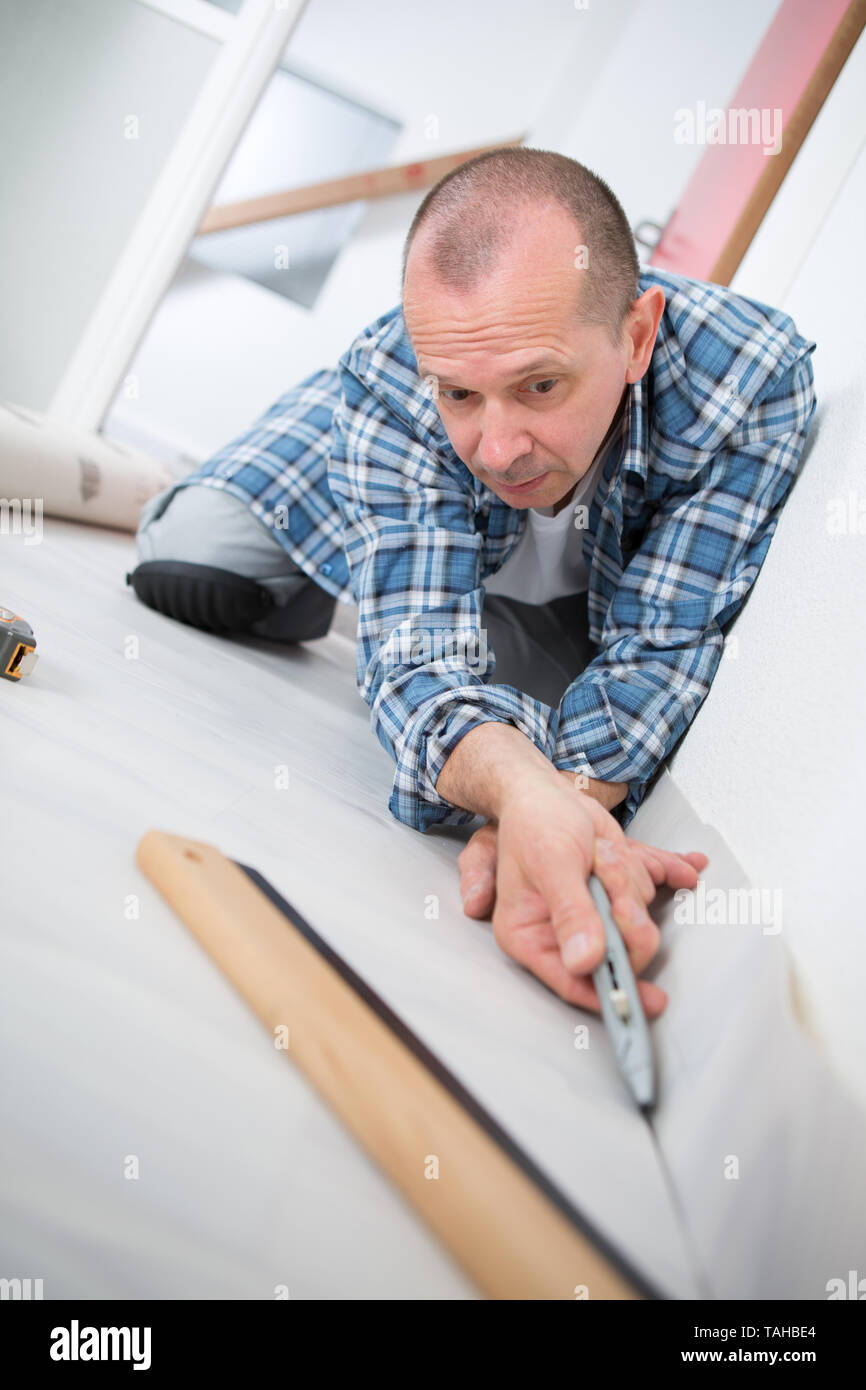 handyman fitting carpet while installation with cutter Stock Photo - Alamy