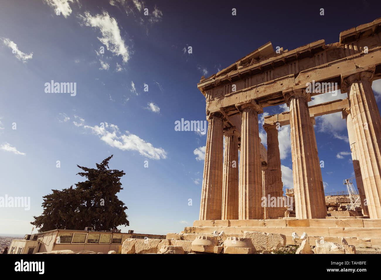 View of the eastern side of the Parthenon with tree and blue sky ...