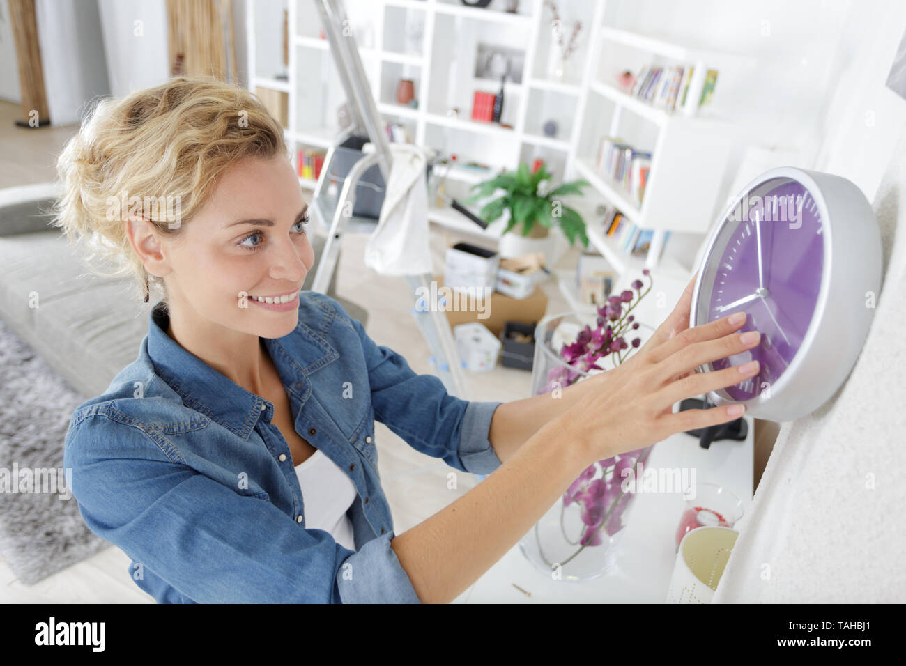 woman putting up a clock Stock Photo - Alamy