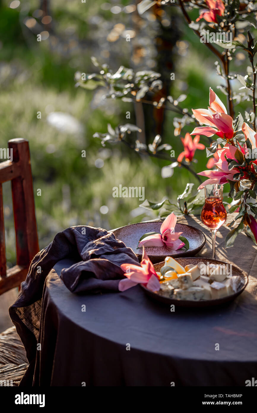 Beautiful table setting in garden on sunset light. Table decorated with ...