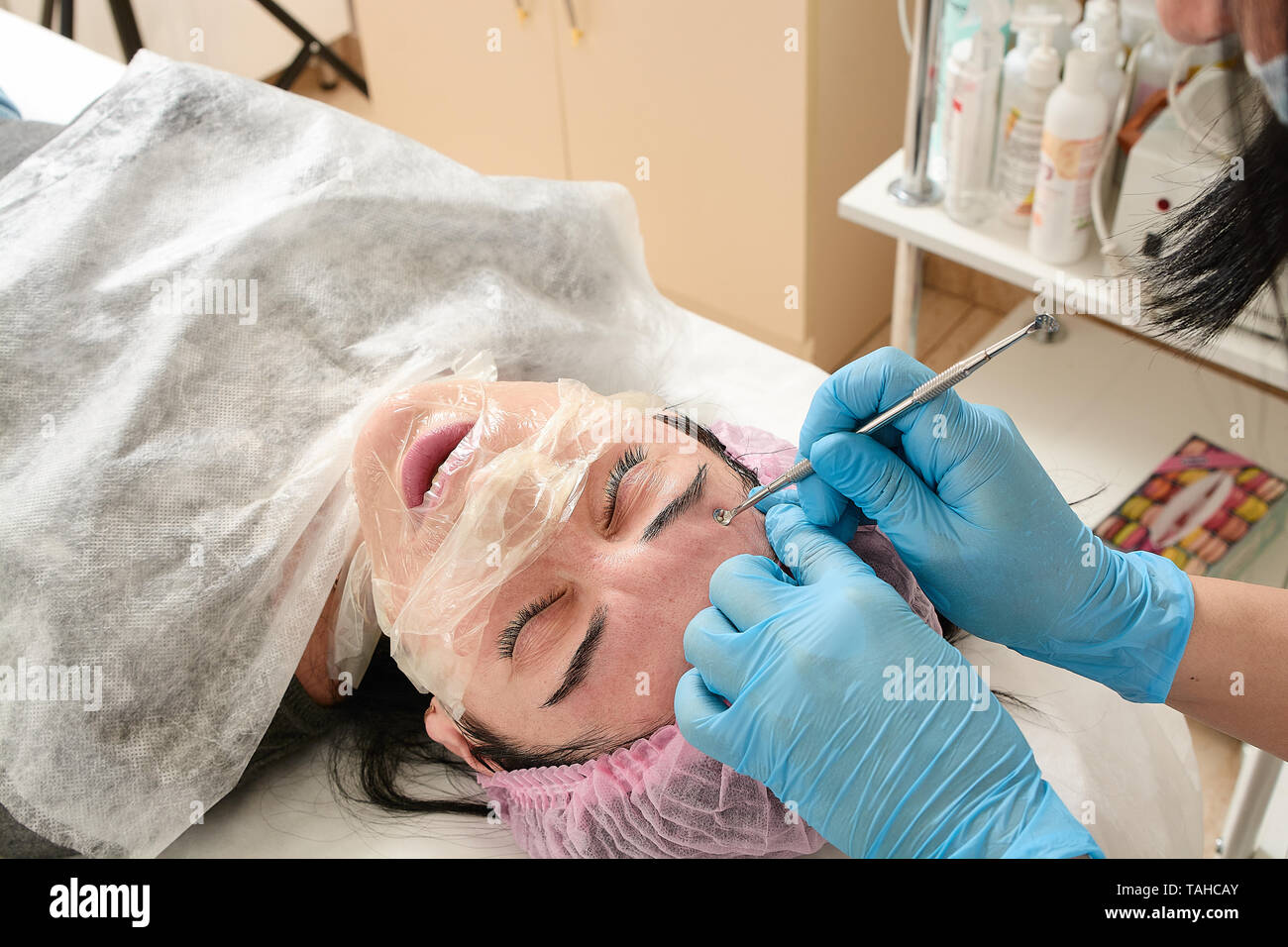 Young woman in beauty salon does manual face cleaning. Manual removal ...