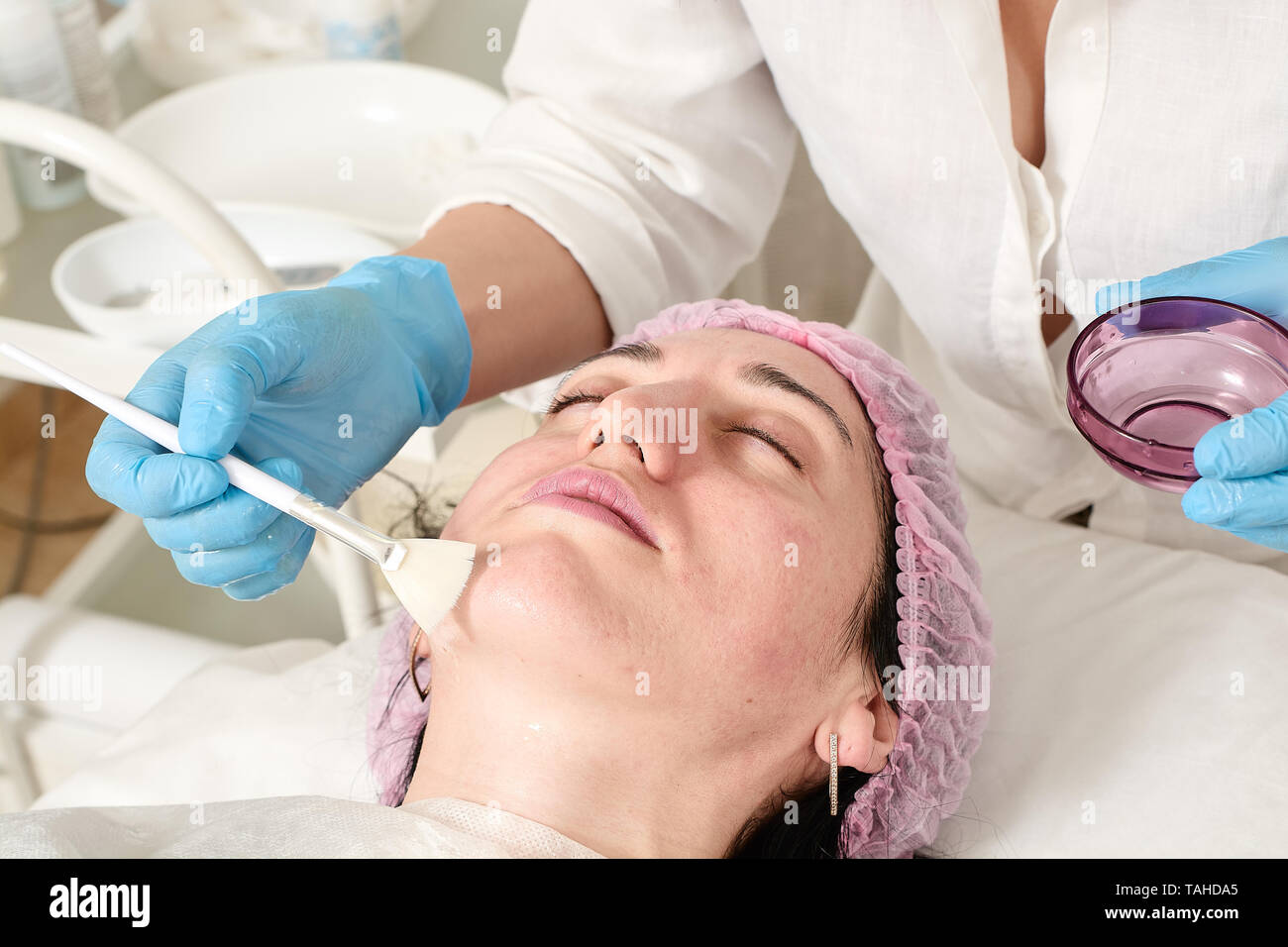 Young woman in beauty salon does skin moisturizing procedure after ...