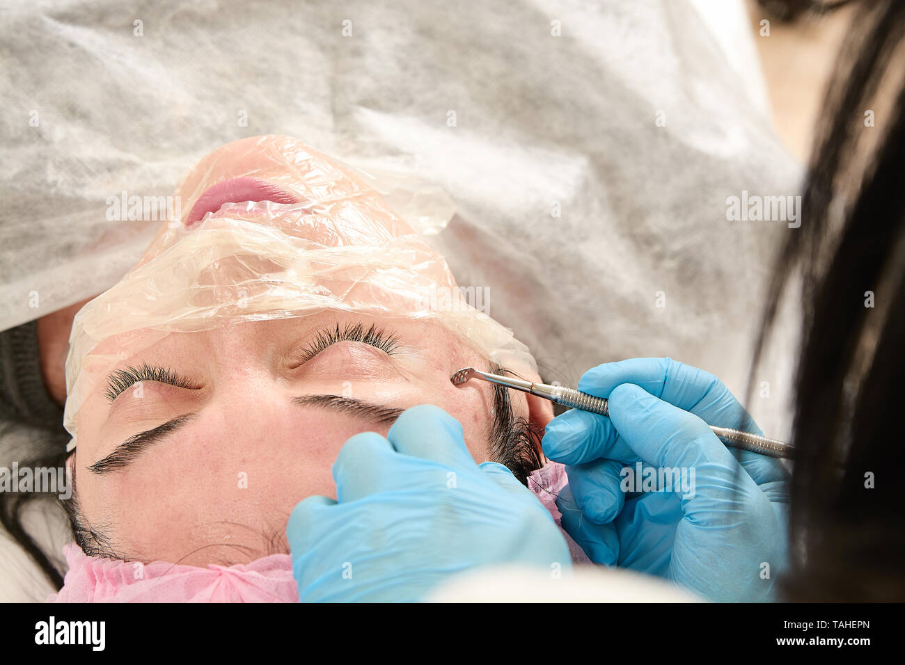Young woman in beauty salon does manual face cleaning. Manual removal ...