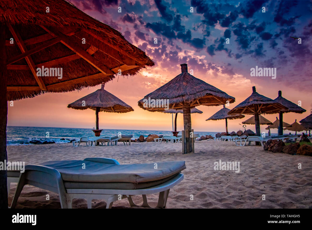 Deck chairs with umrellas on the beach with beautiful sunset in Senegal ...