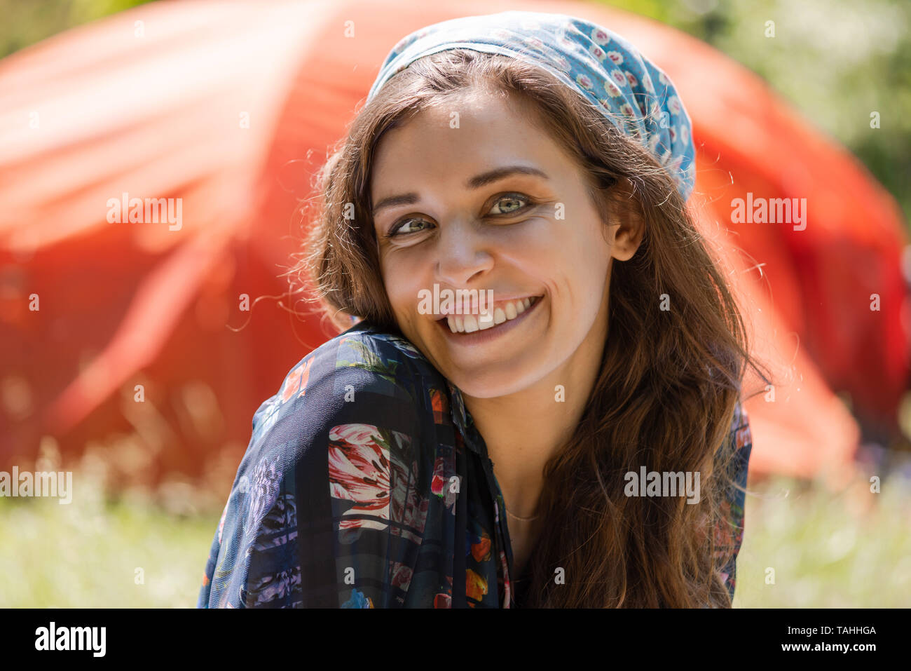 Attractive brunette camper with tent on background Stock Photo - Alamy