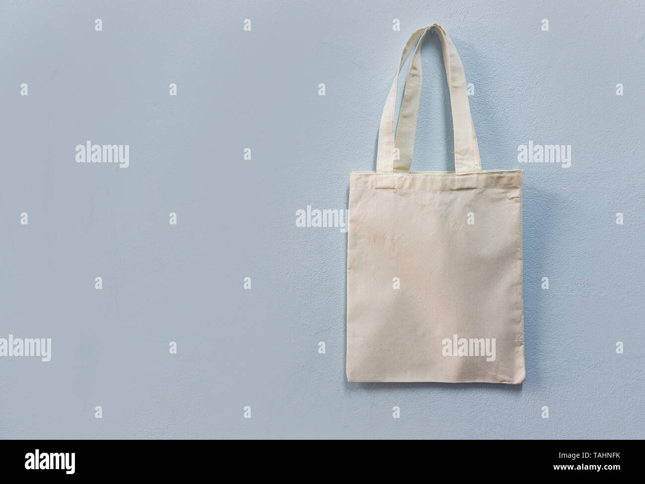 White tote canvas fabric eco bag cloth shopping sack on wall background ...