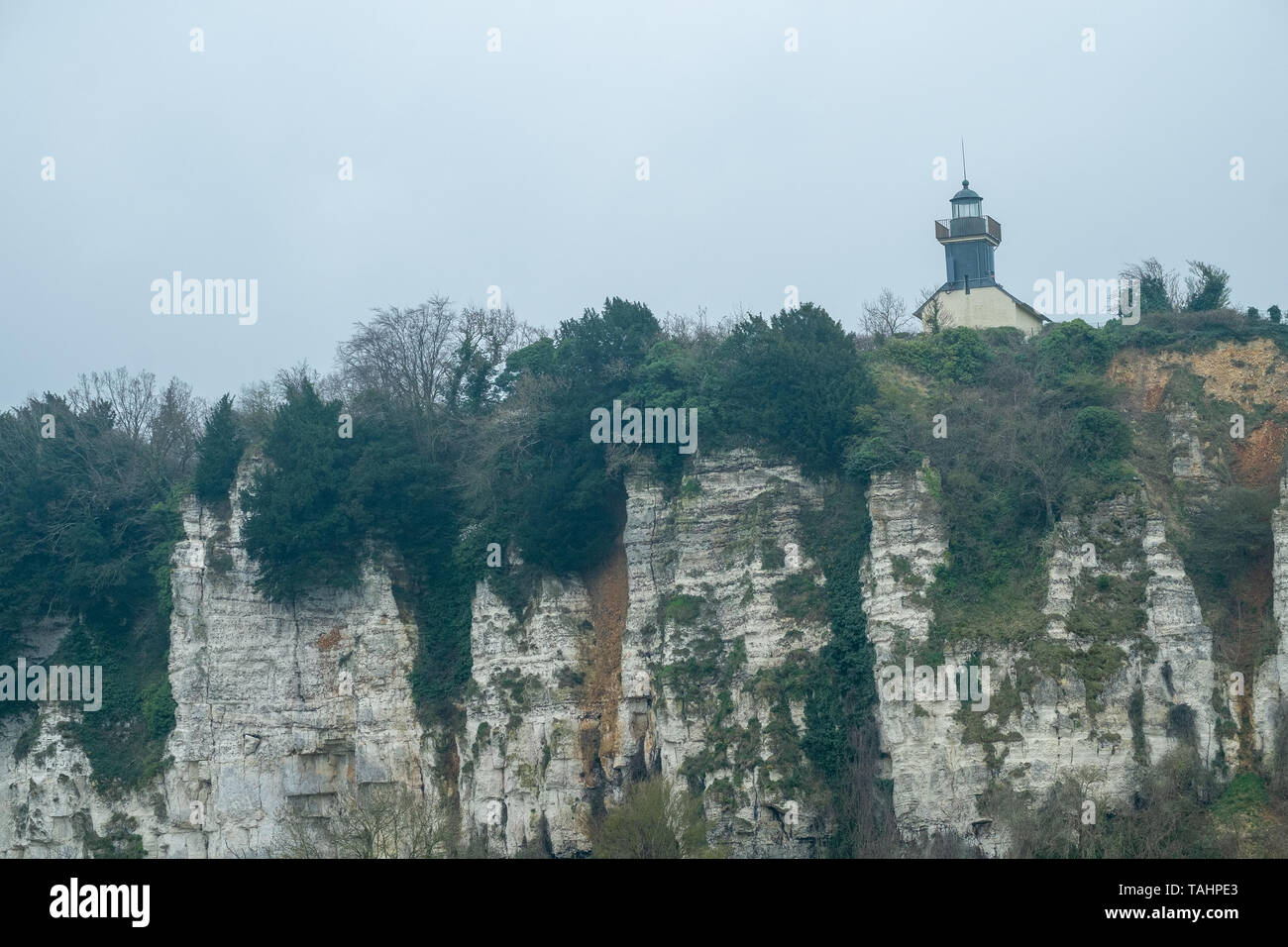 Lighthouse on a chalk cliff under a grey sky in Normandy, France Stock ...