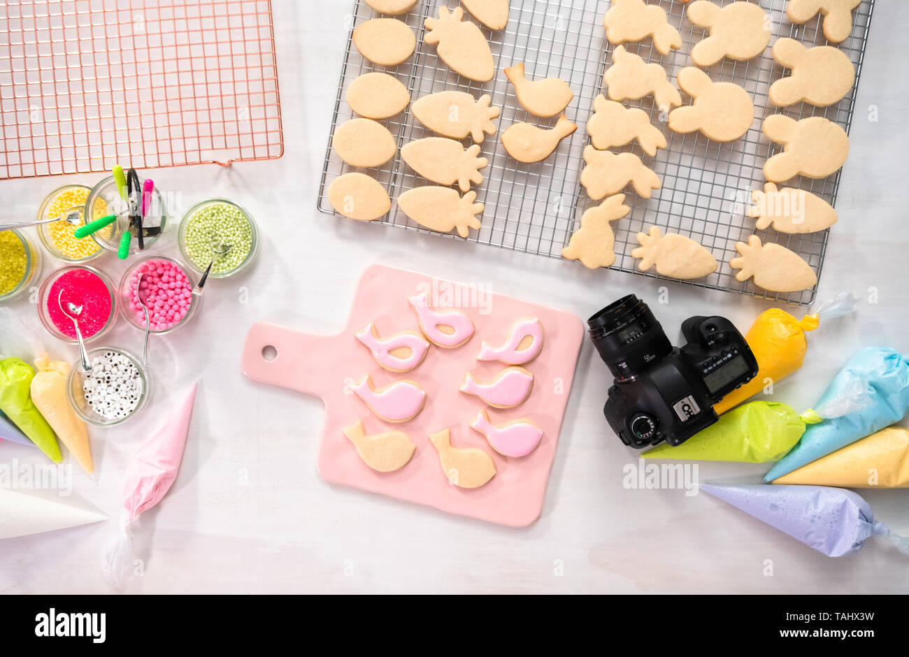 Flat lay. Decorating Easter sugar cookies with rotal icing Stock Photo ...