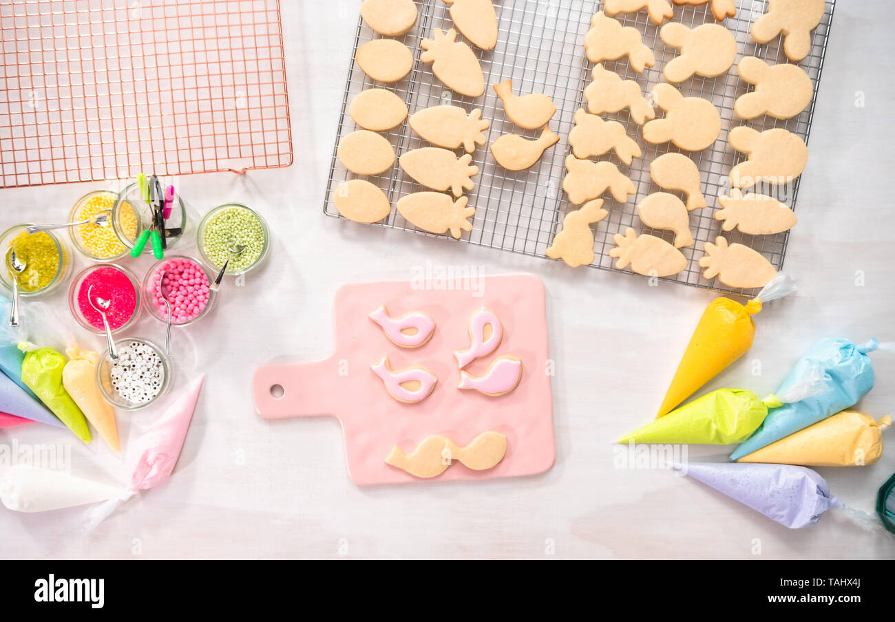 Flat lay. Decorating Easter sugar cookies with rotal icing Stock Photo ...