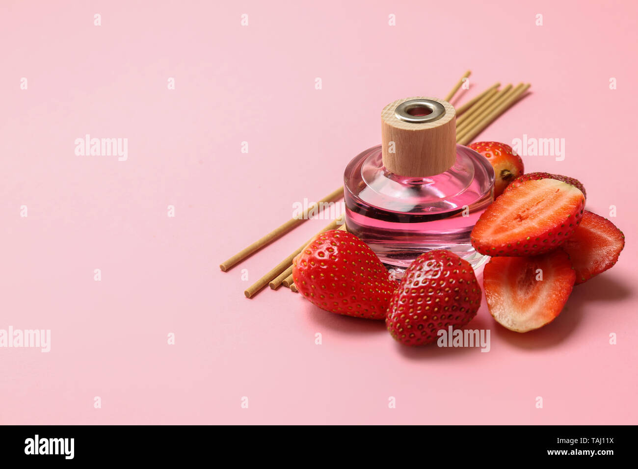 Strawberry reed diffuser on color background Stock Photo - Alamy