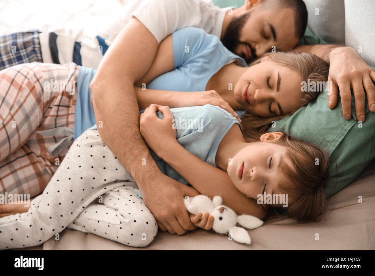 Happy family sleeping in bed at home Stock Photo - Alamy