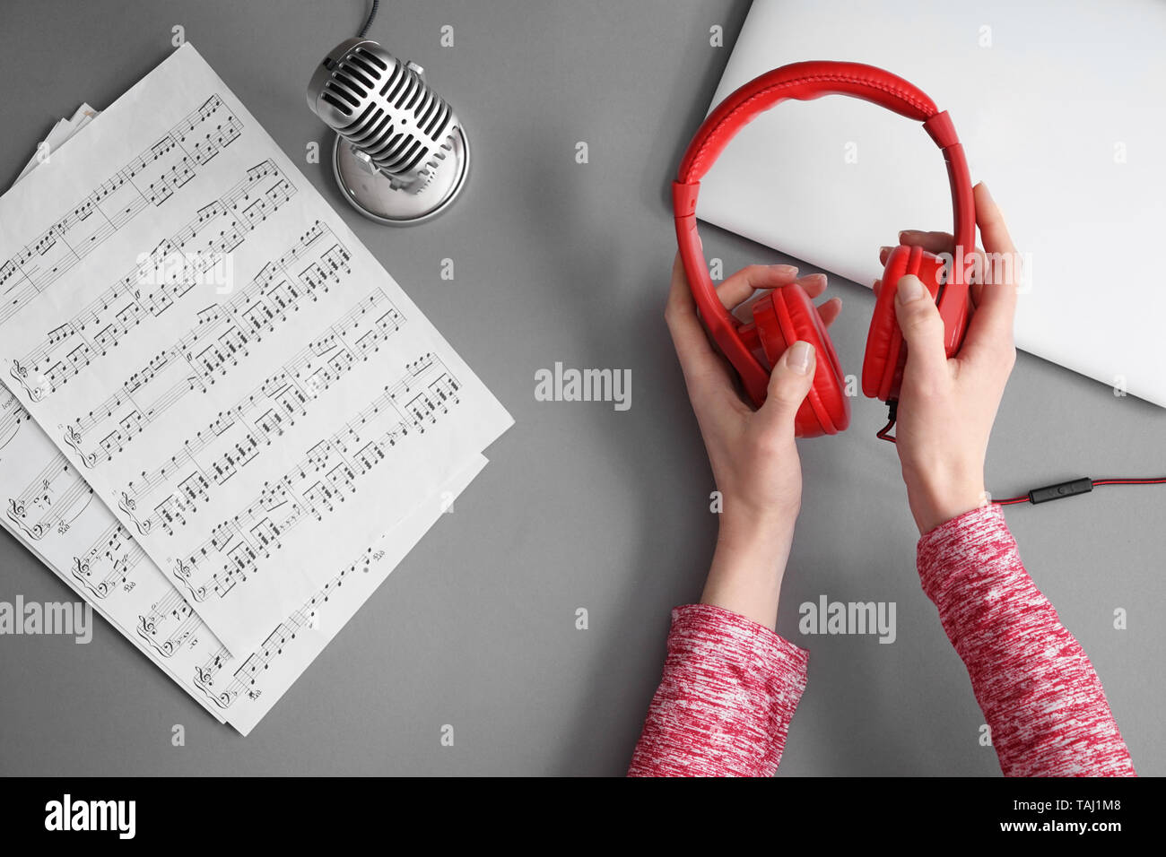 Female composer with music notes, microphone and headphones on grey ...