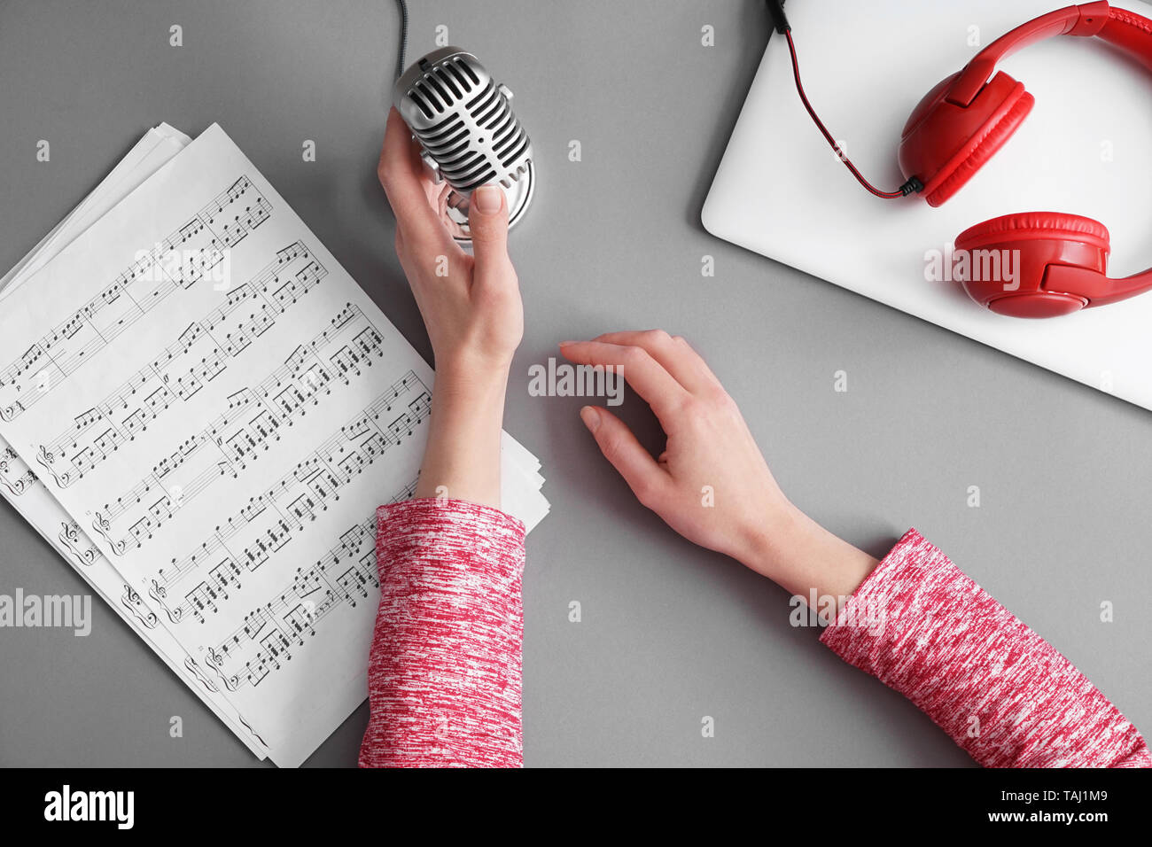 Female composer with music notes, microphone and headphones on grey ...