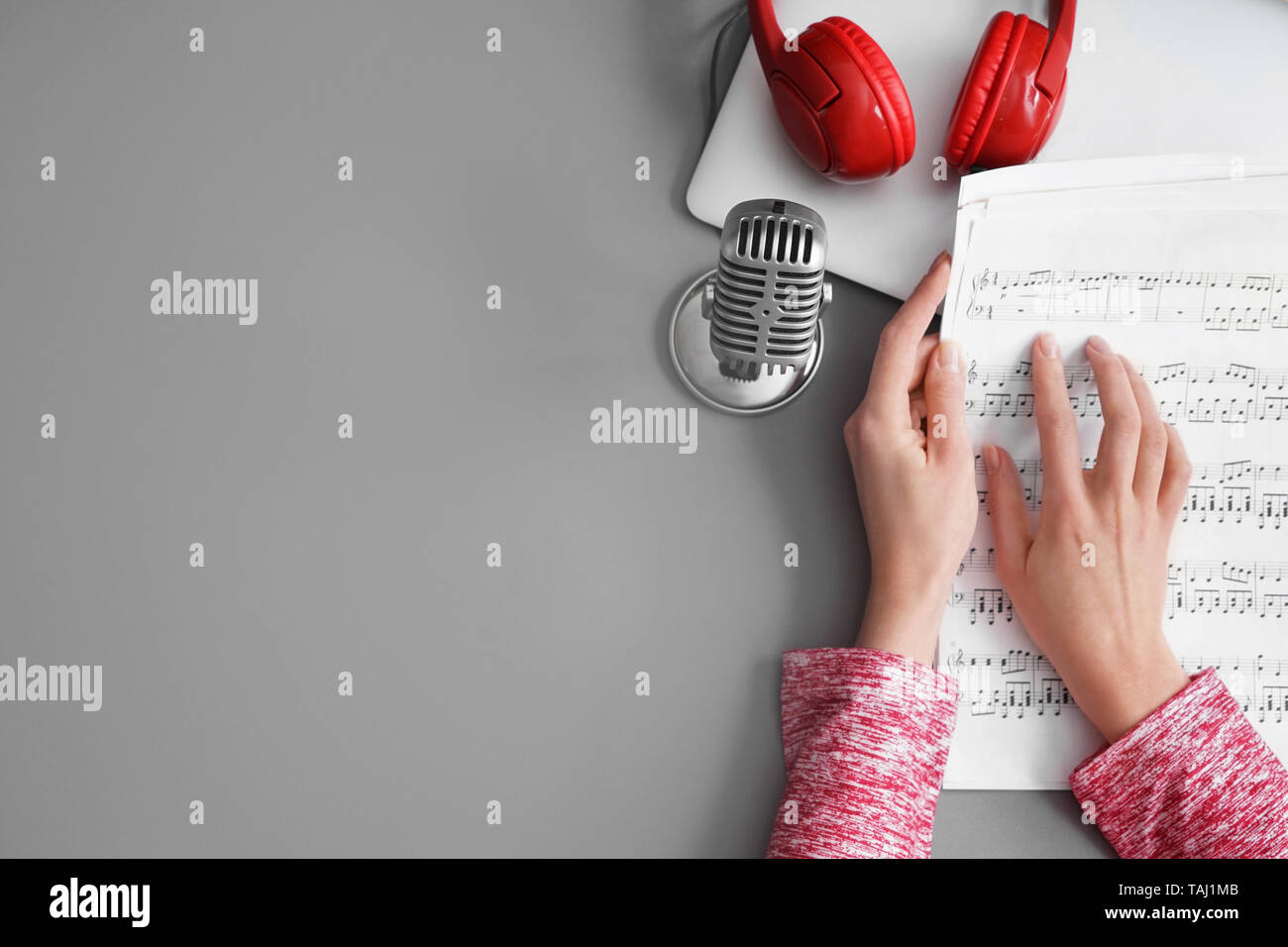 Female composer with music notes, microphone and headphones on grey ...