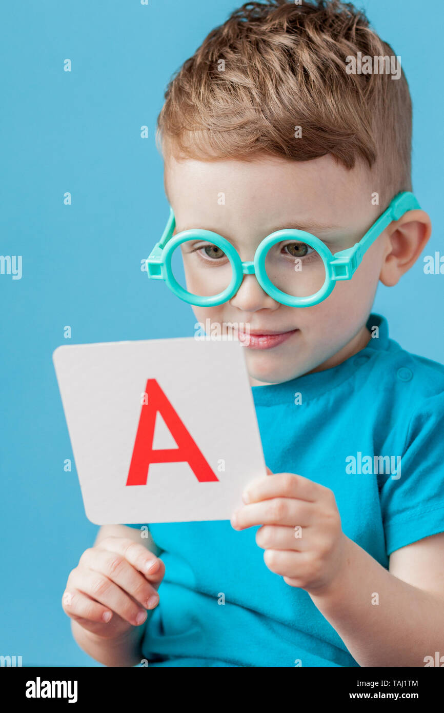 Cute little boy with letter on background. Child learn letters ...