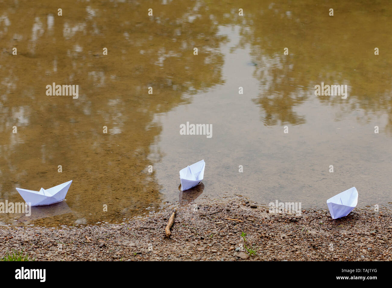 White paper toy boat on blue water near the shore Stock Photo - Alamy