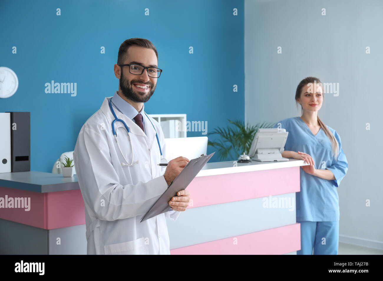 Doctor and female receptionist near desk in clinic Stock Photo - Alamy
